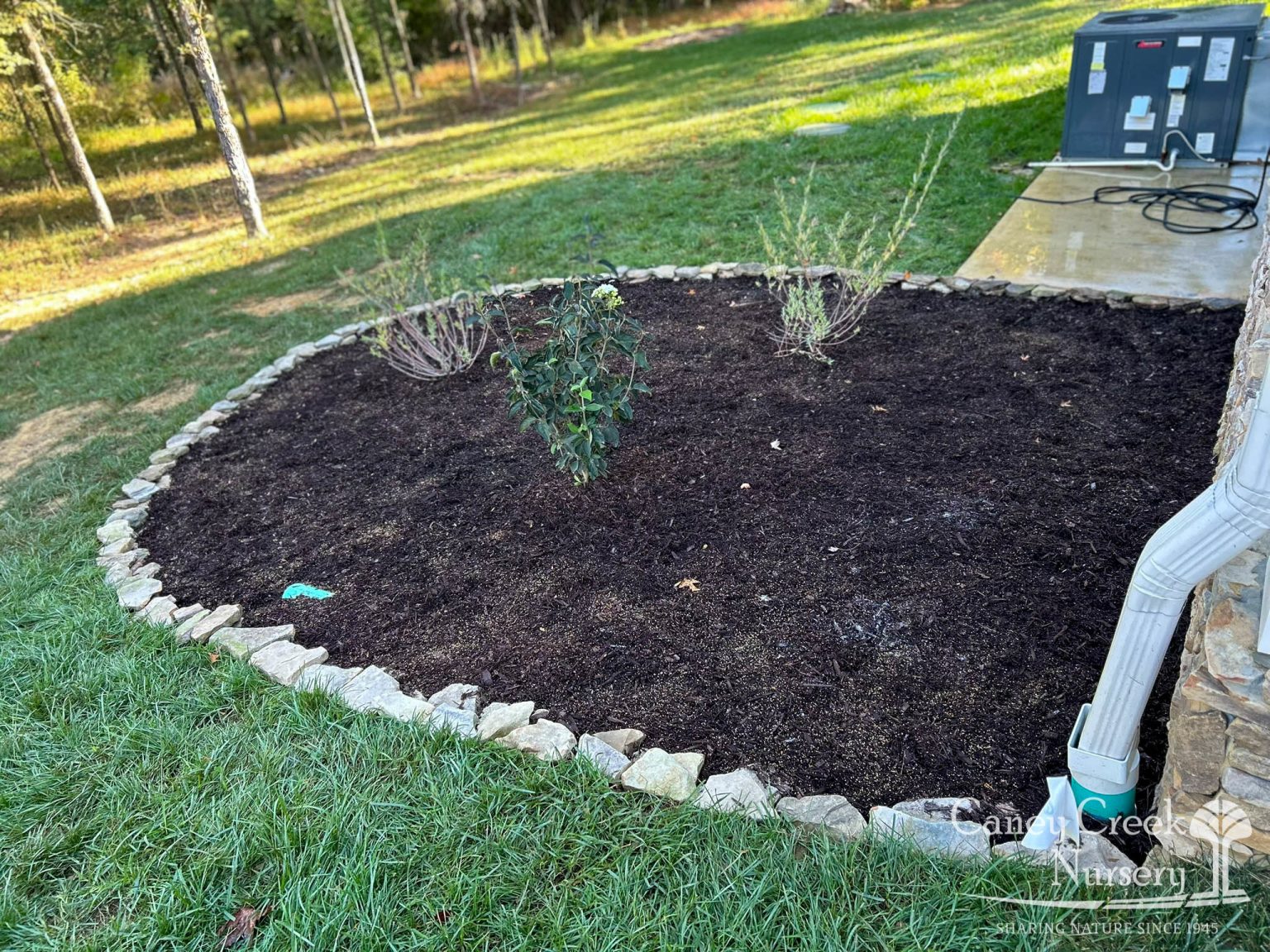 Utility Screen with Stacked Stone Edging - Caney Creek Nursery